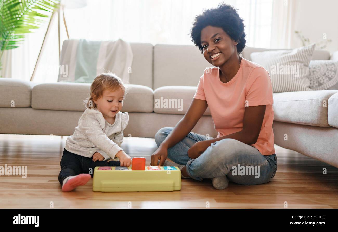 nursery babysitter with baby play with toys Stock Photo - Alamy