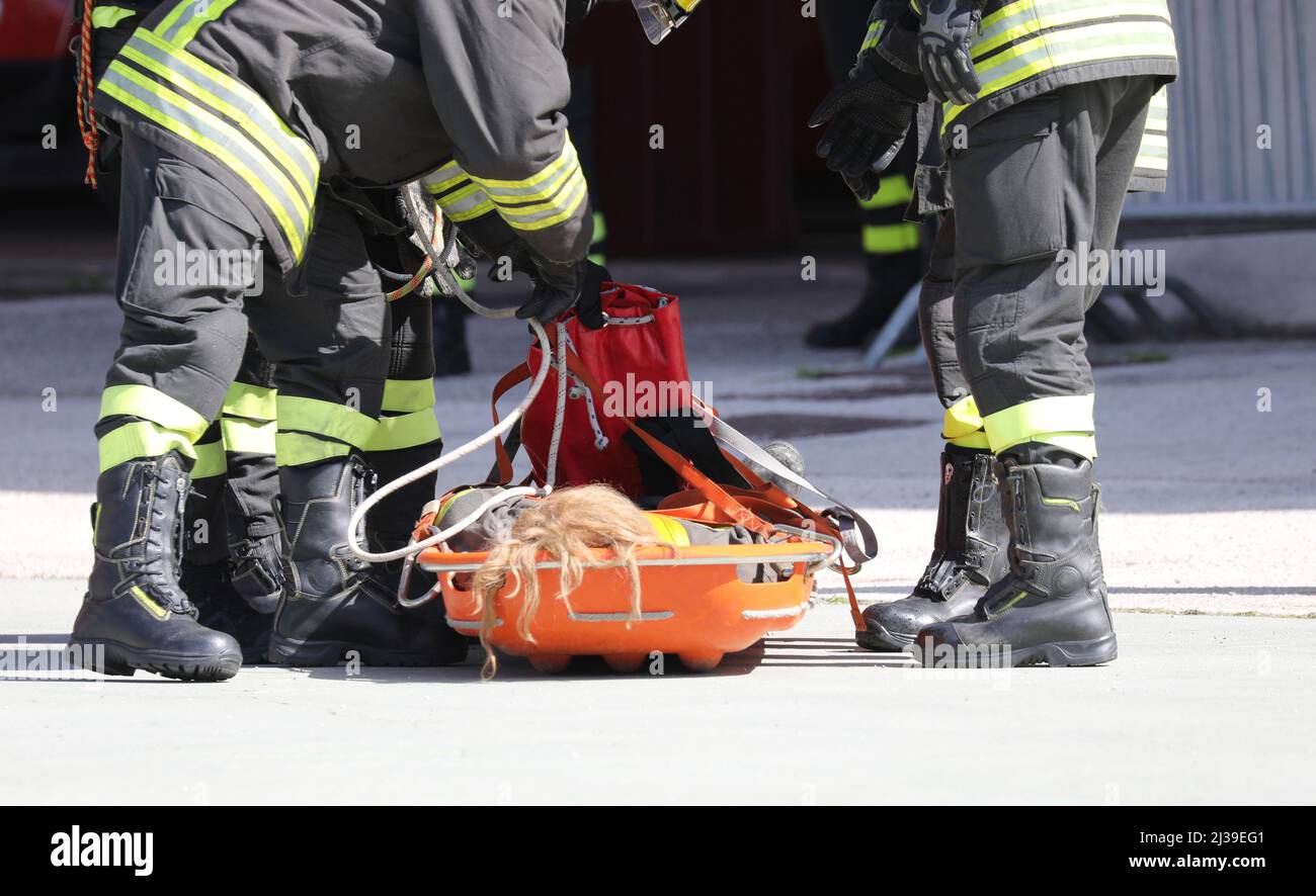 firefighters carrying a injured person with stretcher Stock Photo - Alamy