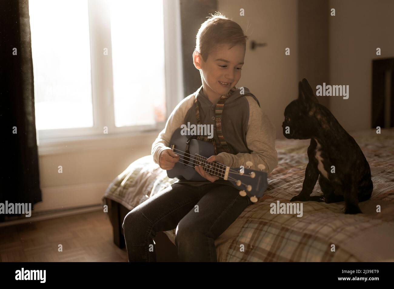 A Cheerful Caucasian boy playing guitar on his bedroom Stock Photo - Alamy