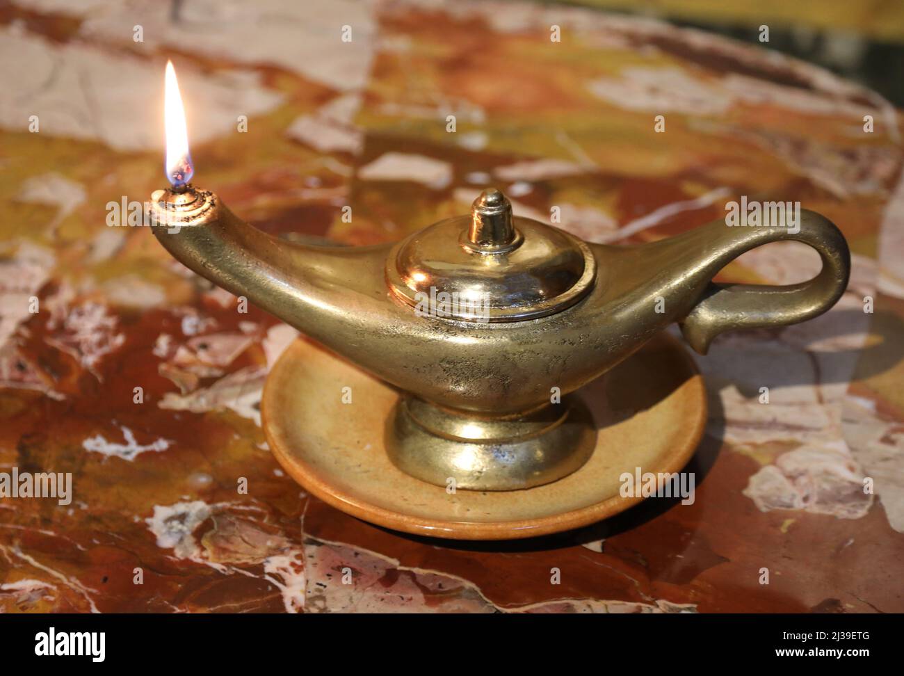 ancient gilded oil lamp with lit flame n the temple Stock Photo - Alamy
