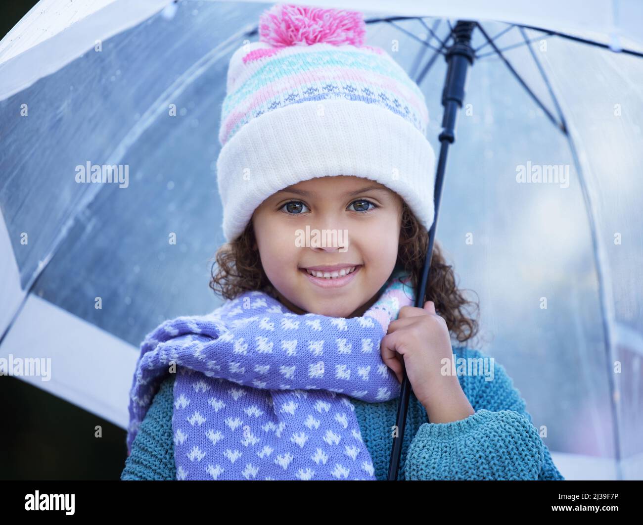Ive been waiting for the rain all week. Shot of an adorable little girl standing alone outside ...