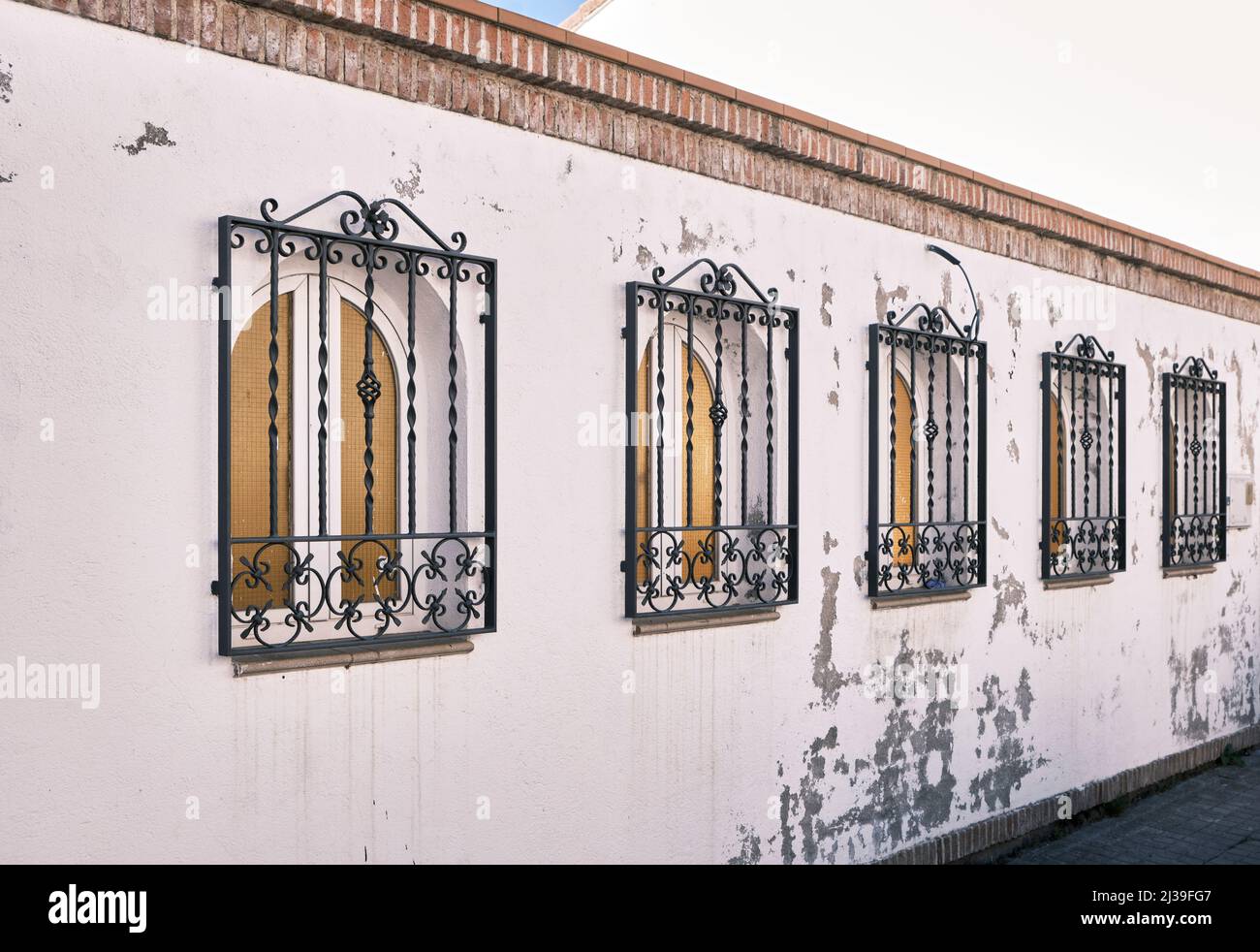 Perspective view of a weathered building wall with arched shape windows ...