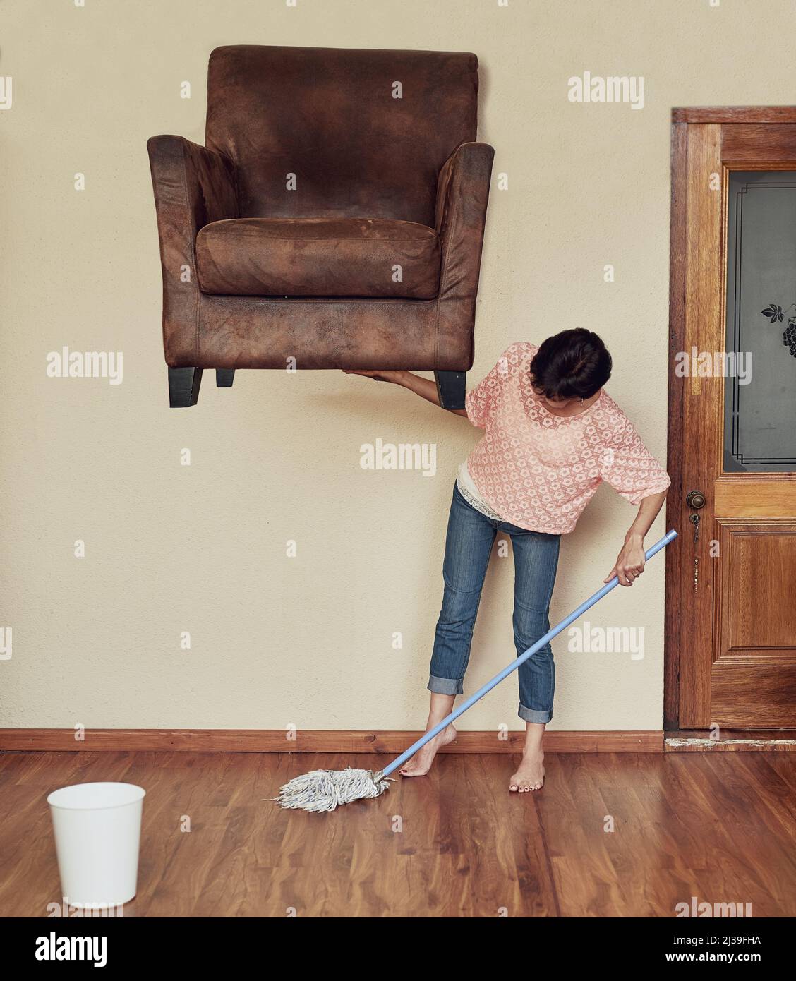 No task is too difficult for her. Shot of a woman lifting a couch to ...