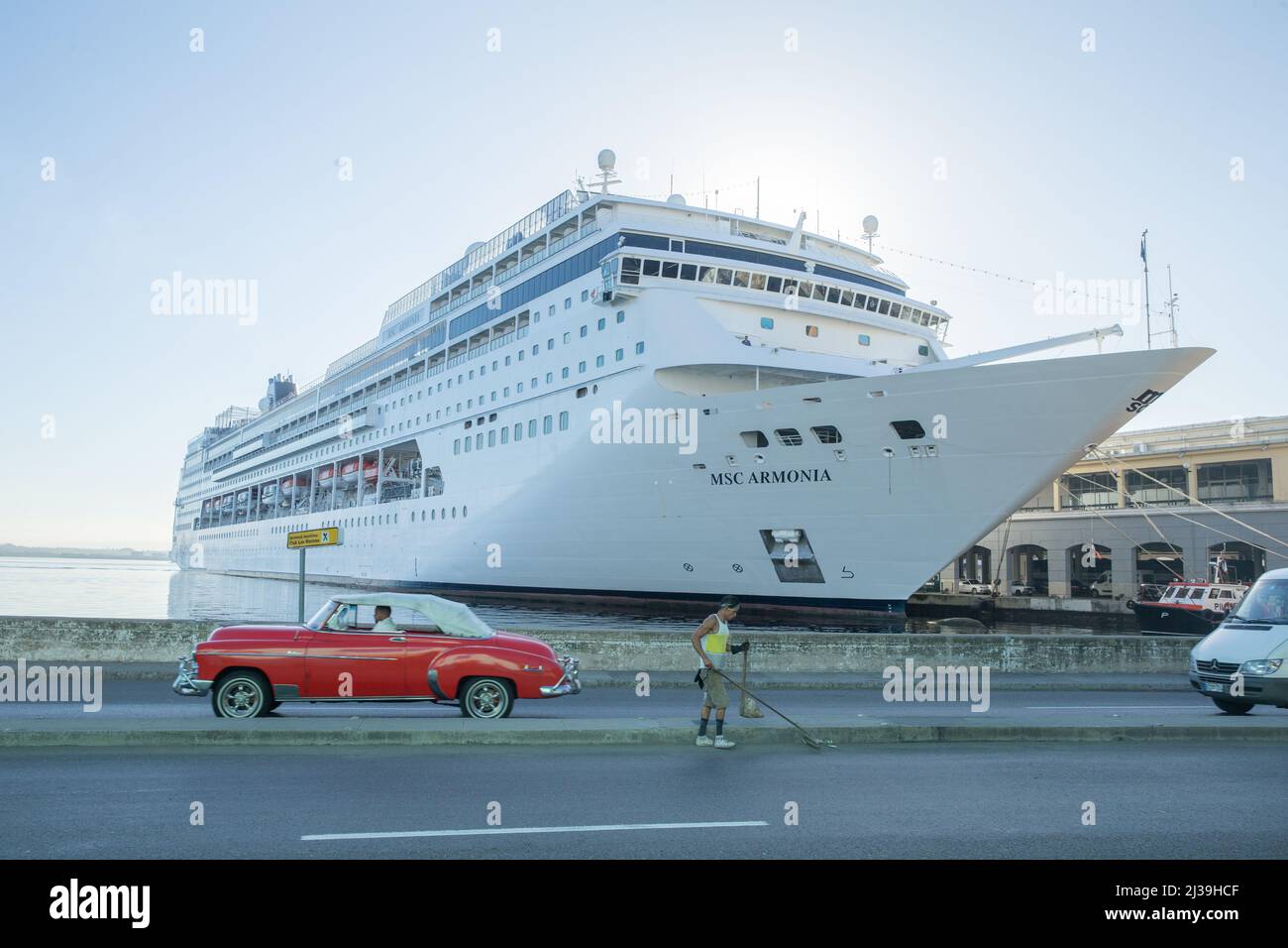 A classic American Car passes by the MSC Armonia cruise ship docked in ...