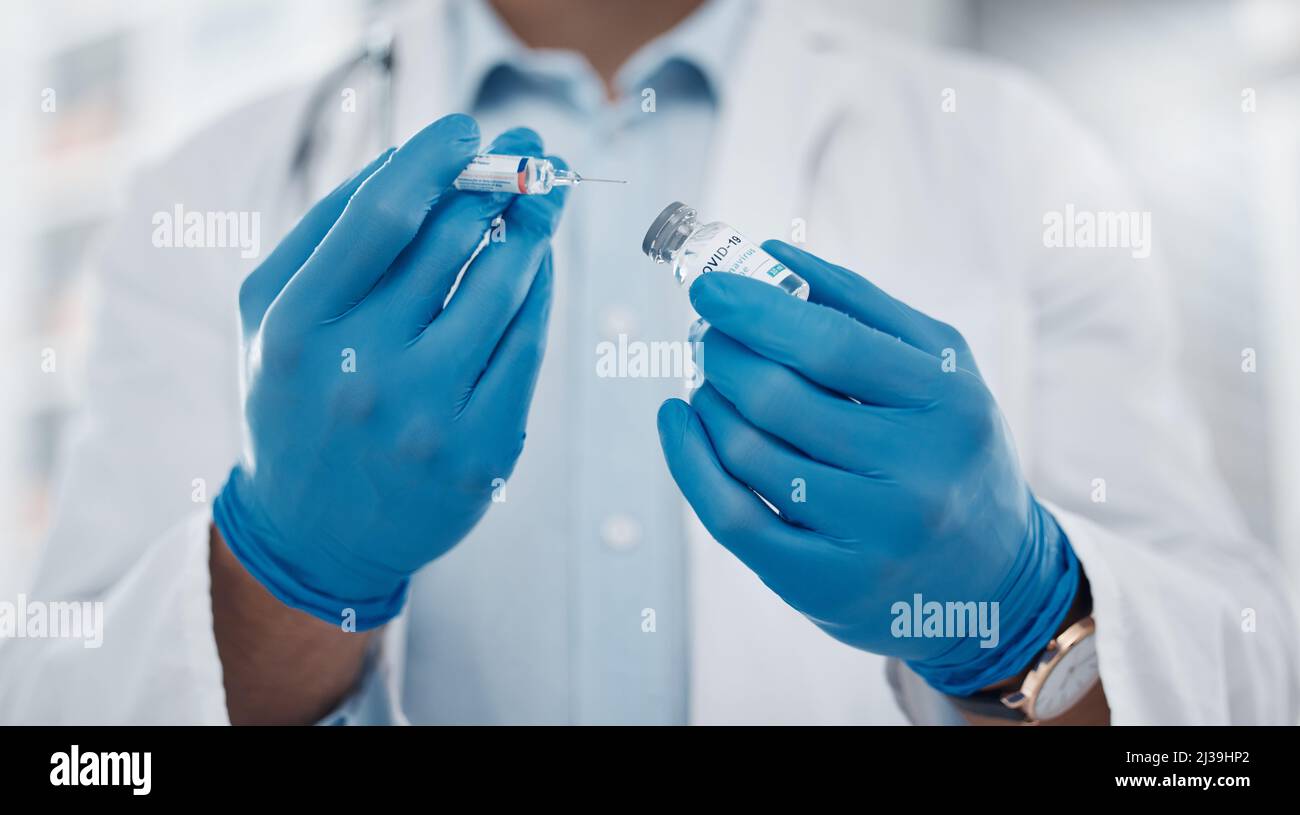 Preparing the next dose. Cropped shot of an unrecognizable male doctor ...