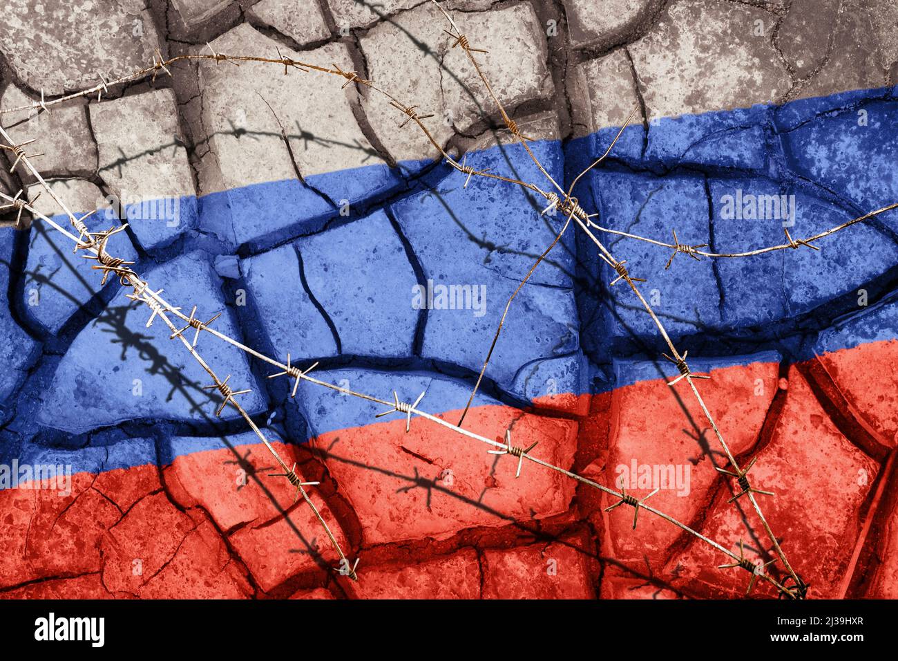 Cracked wasteland in the colors of the Russian flag behind barbed wire ...