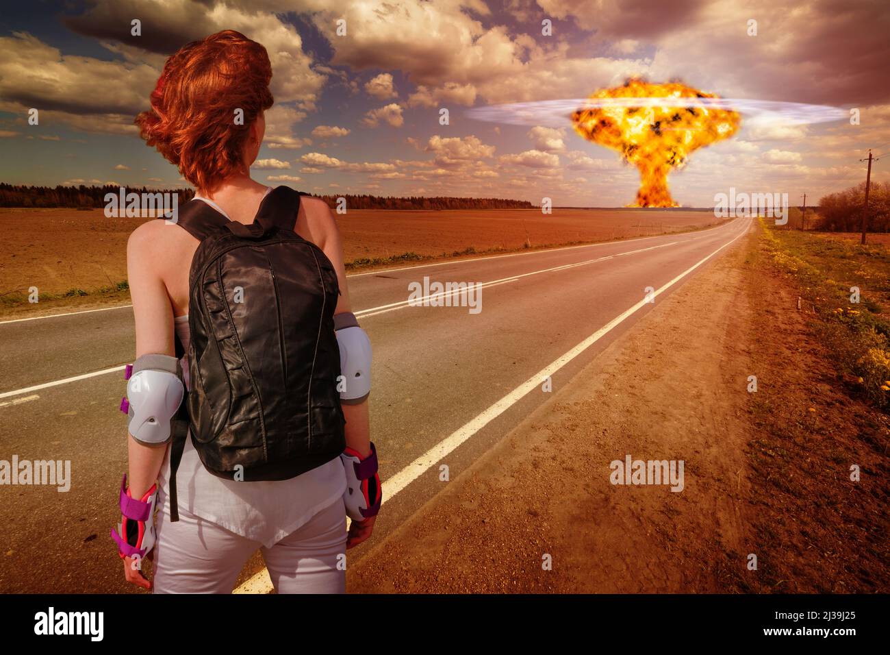 Active young woman in sportswear looking at distant nuclear explosion ...