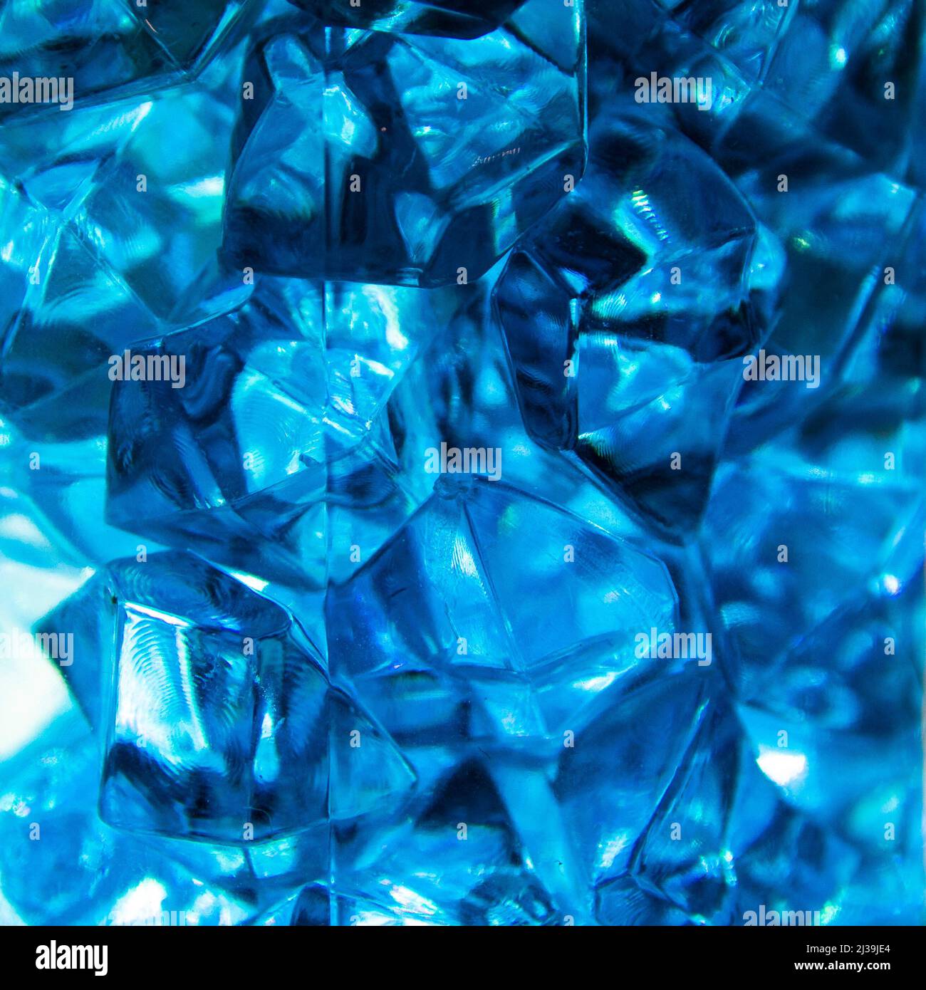 Bright blue crystals made of glass look like gems close-up in the blur ...