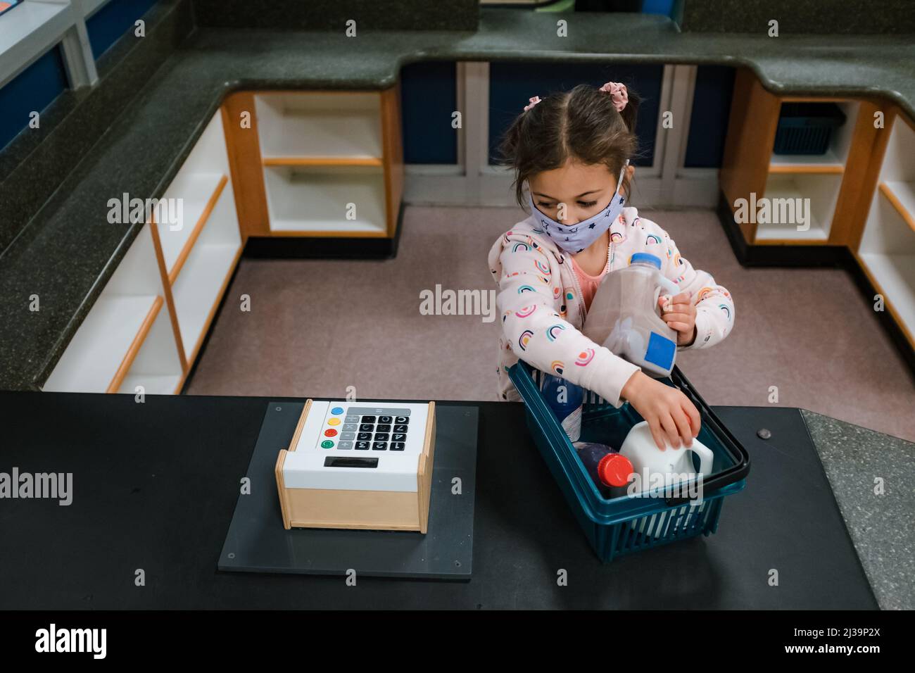 Girl playing with toy cash register Stock Photo - Alamy