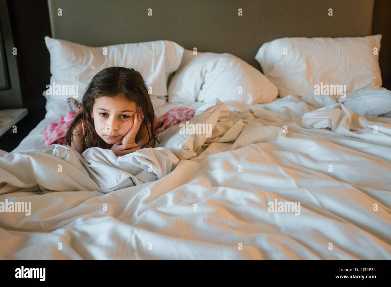 Young girl looking sad in messy bed Stock Photo - Alamy