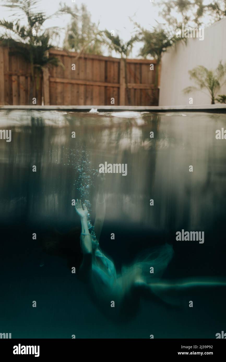 woman sinking in pool wearing a dress with bubbles Stock Photo - Alamy