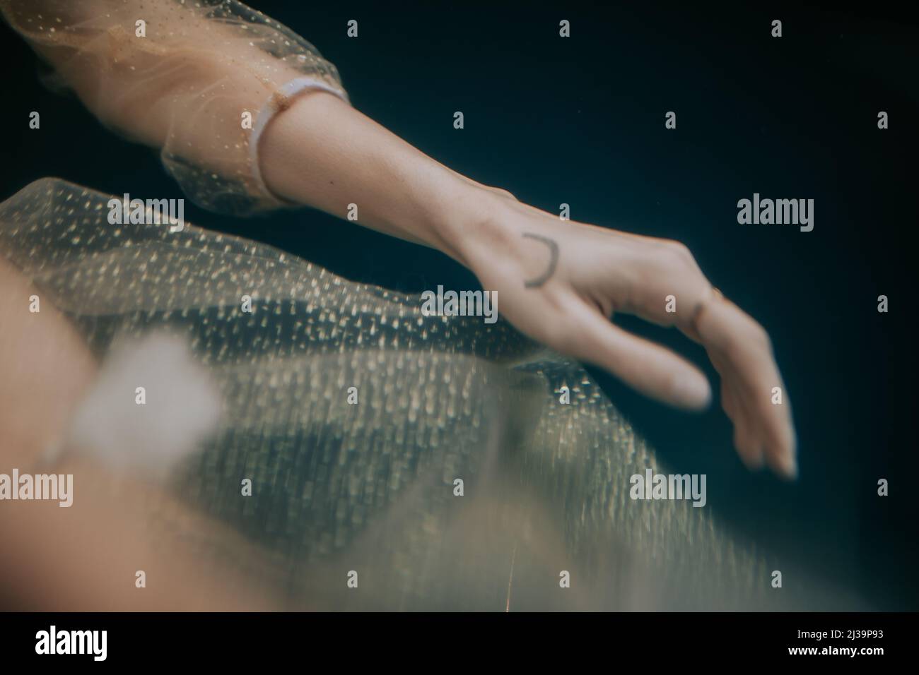 hand with tattoo in sparkle dress floating underwater Stock Photo - Alamy