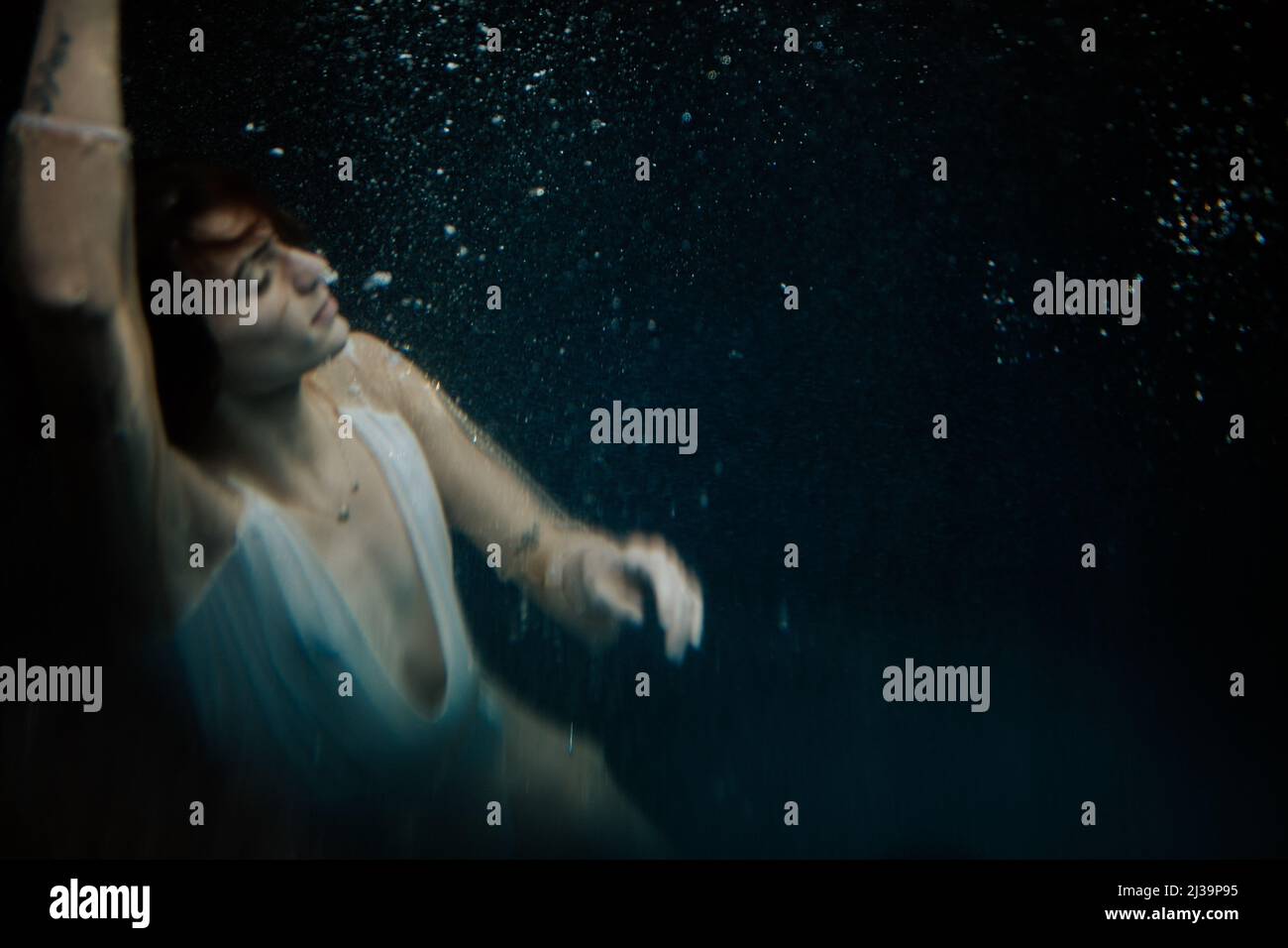 woman floating underwater with tattoos swimming in bubbles Stock Photo ...