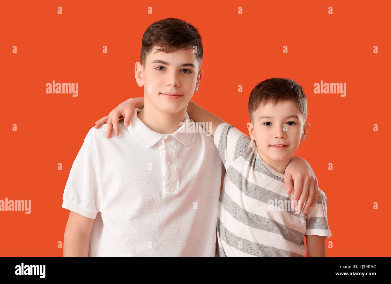 Portrait of cute brothers on color background Stock Photo - Alamy