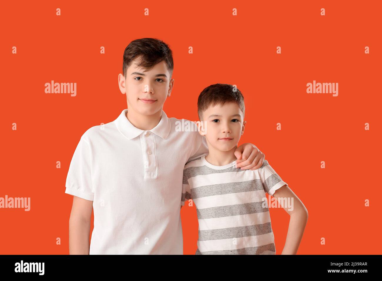 Portrait of cute brothers on color background Stock Photo - Alamy