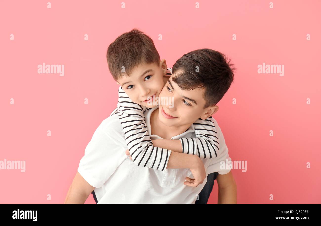 Portrait of cute brothers on color background Stock Photo - Alamy