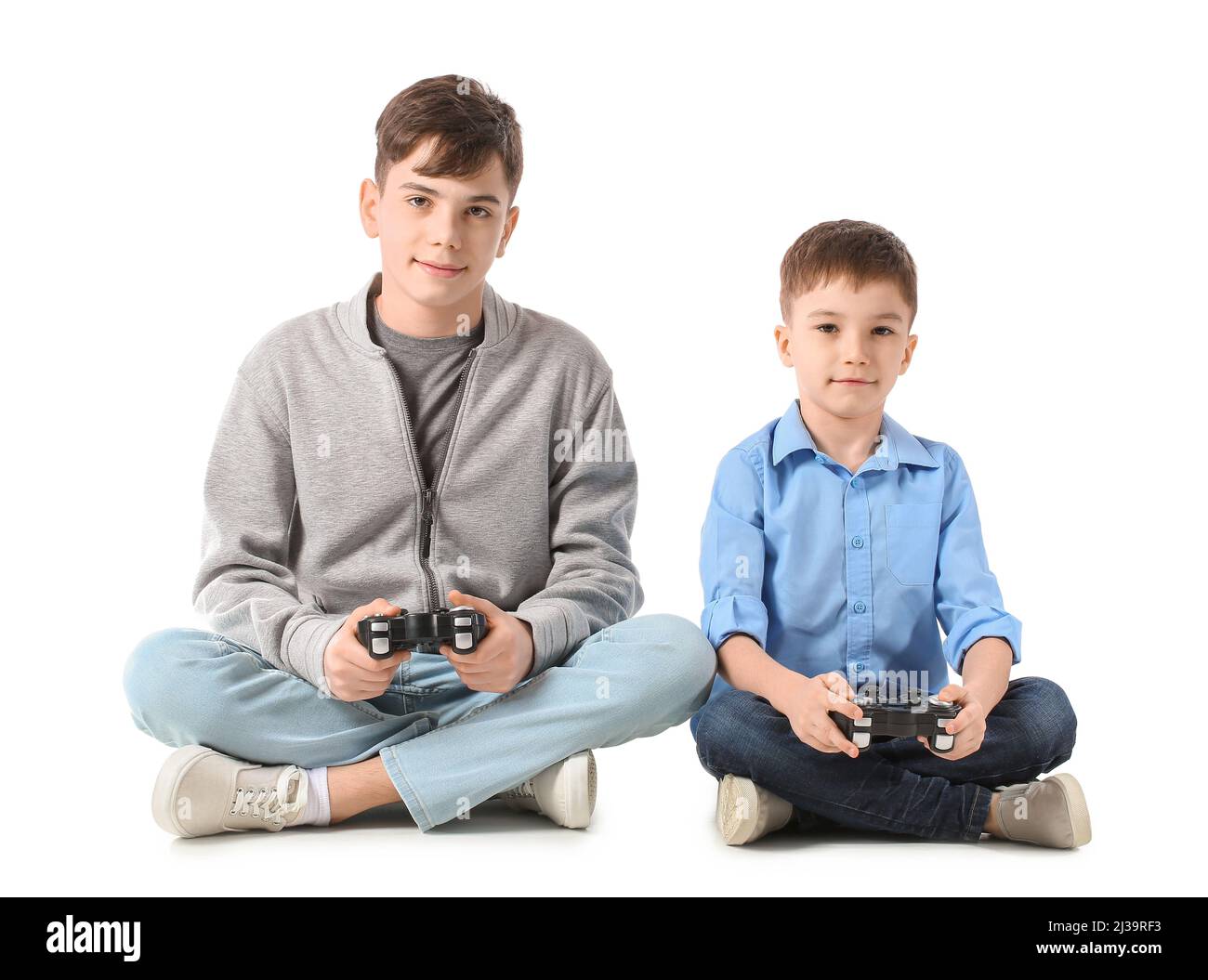 Cute brothers playing video game on white background Stock Photo - Alamy