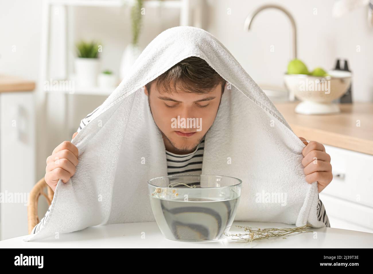 Young man doing steam inhalation at home to soothe and open nasal ...