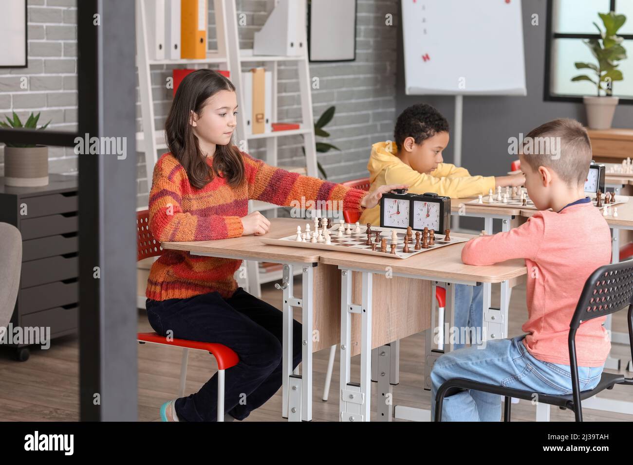 Little children playing chess during tournament in club Stock Photo - Alamy
