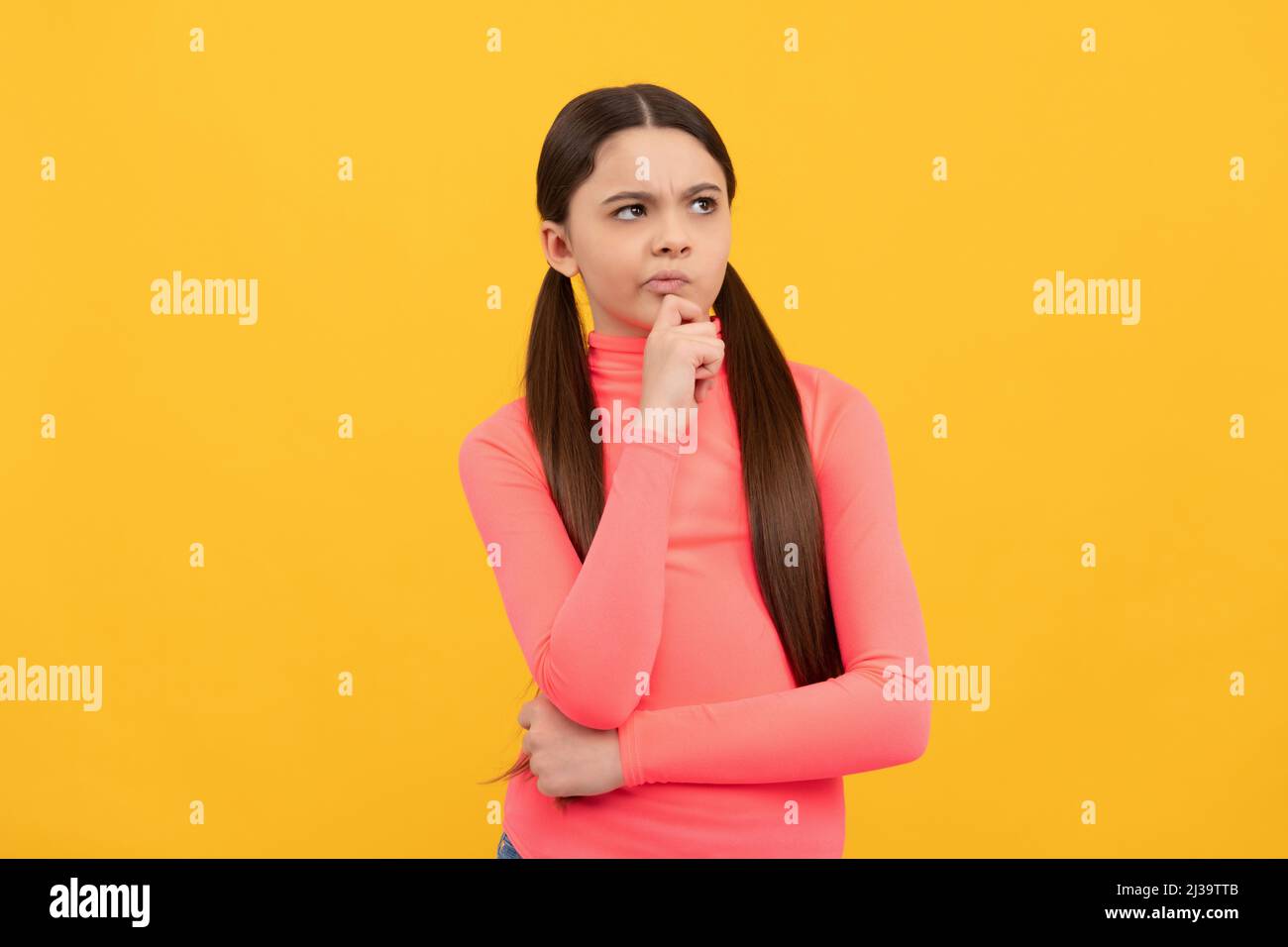 thoughtful teen girl with long hair on yellow background, decision ...