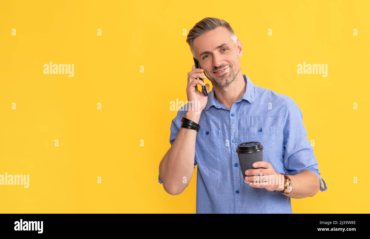 smiling handsome man use smartphone with coffee cup. man drinking ...