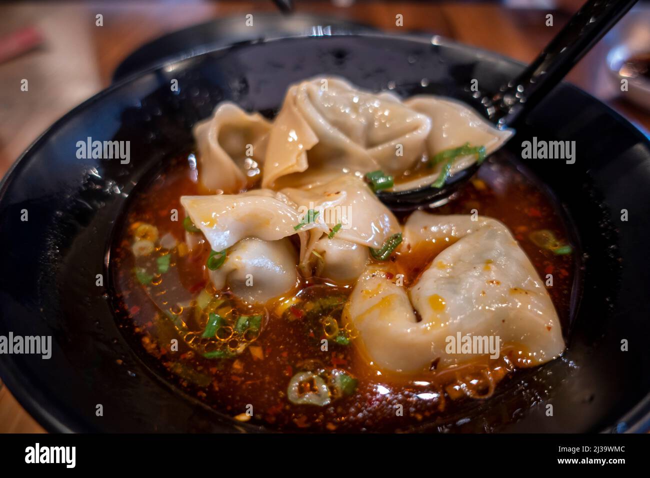 Close up, selective focus on dumplings inside a bowl of hot and sour ...