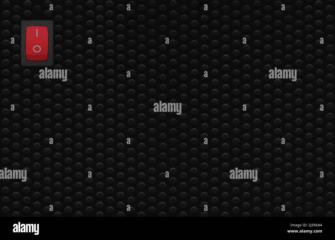 Red rectangle rocker power switch in on position, black abstract dot ...