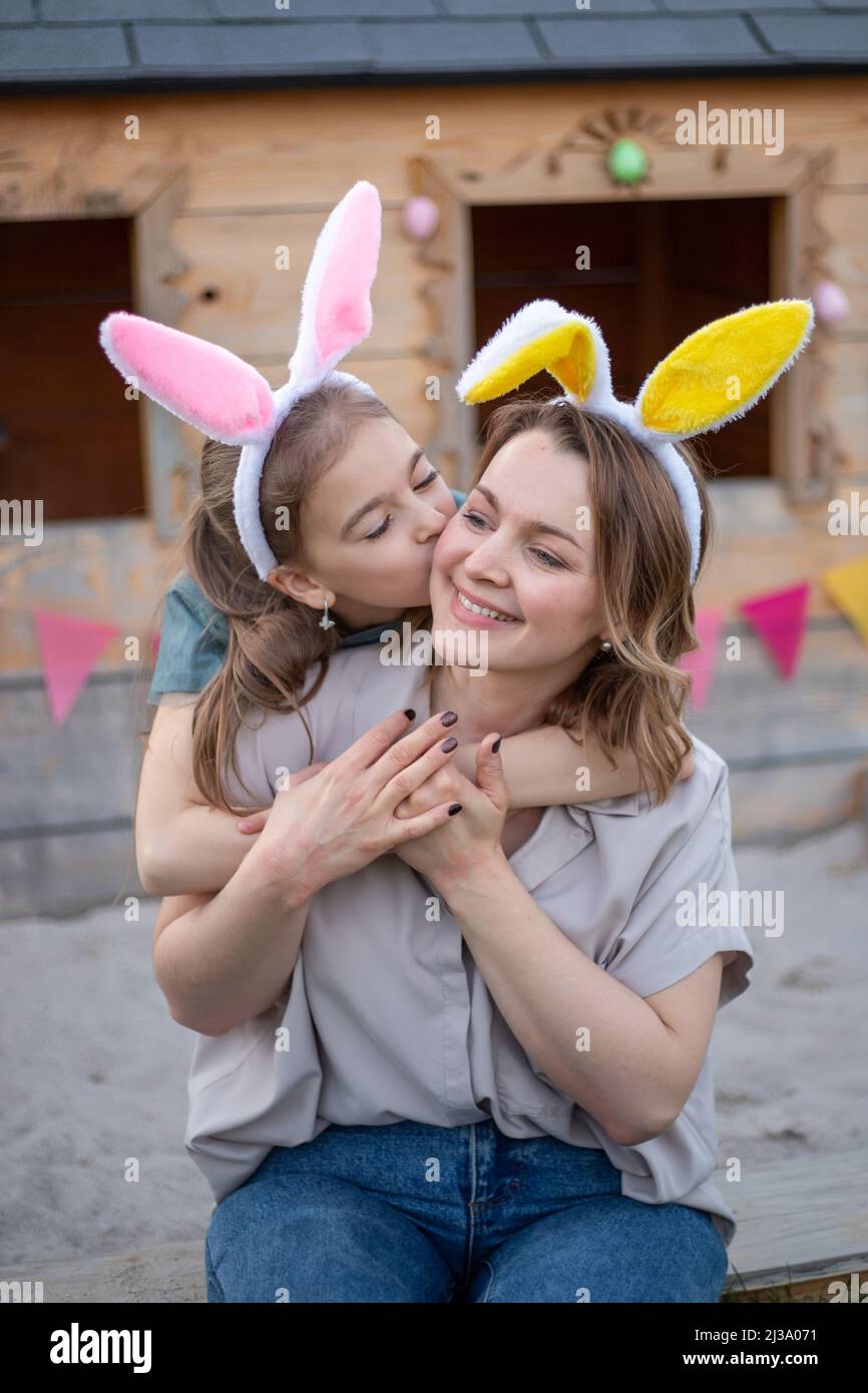 Attractive young woman hugging her cute little daughter. Easter ...