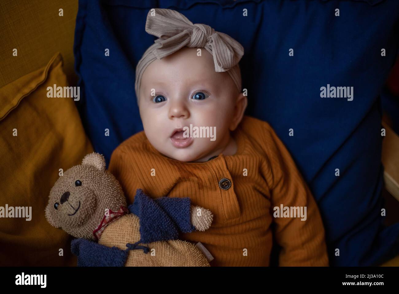 baby girl sitting with teddy bear and smiles Stock Photo - Alamy
