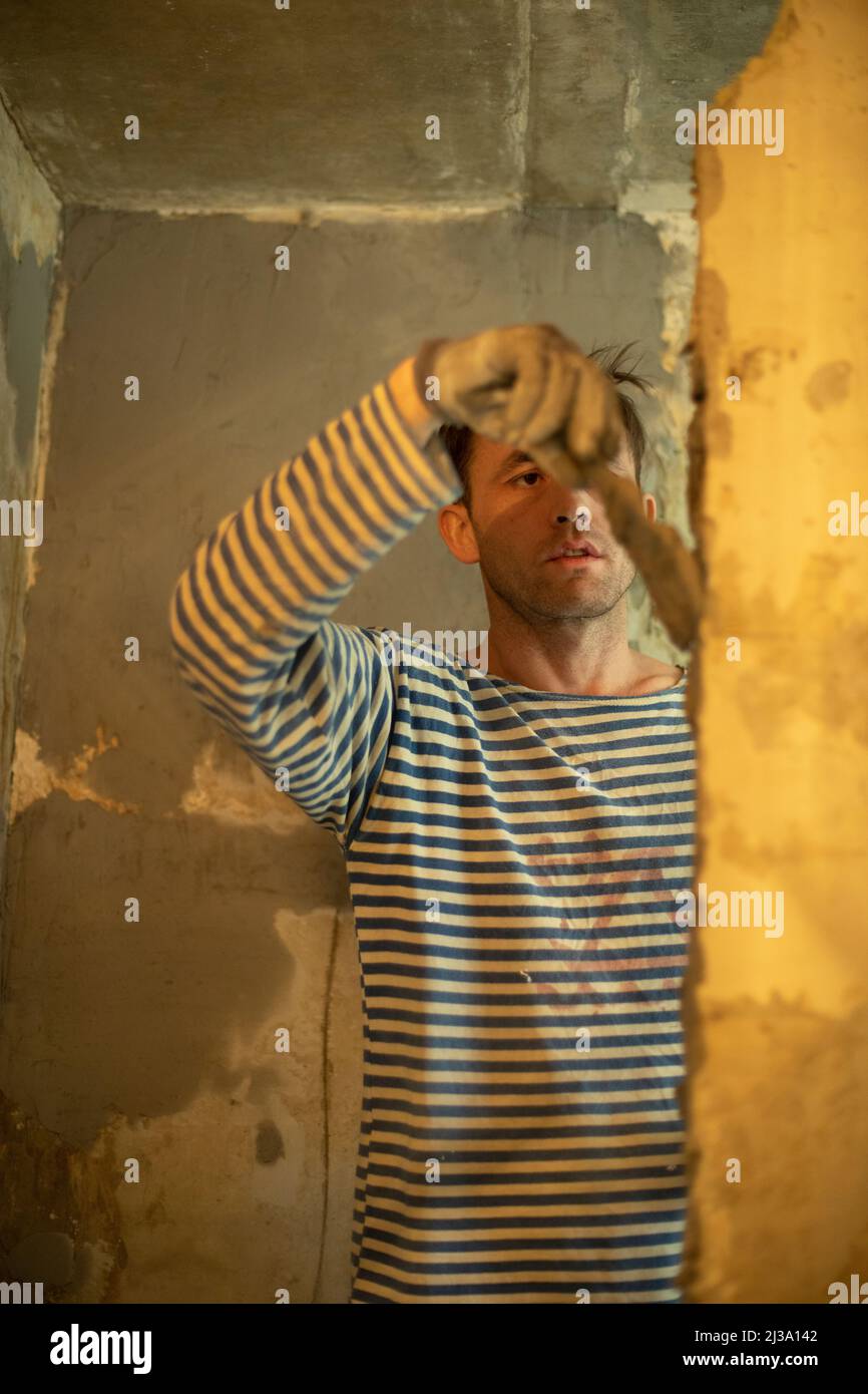 Man plasters wall. Tool in man's hand. Person makes repairs. Manual ...