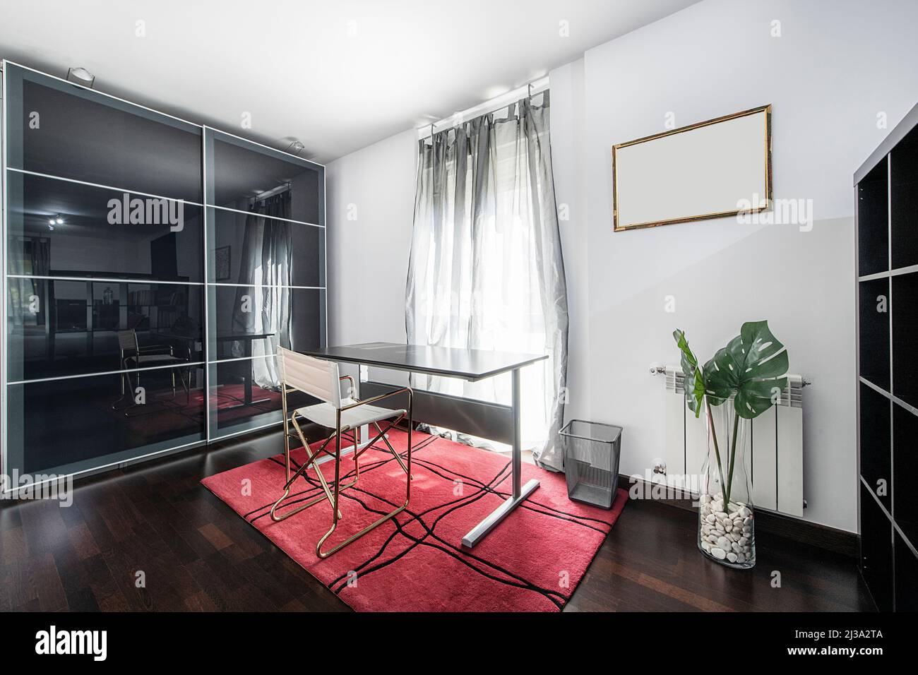 Dark office desk area in bedroom with sliding glass wardrobe, red ...