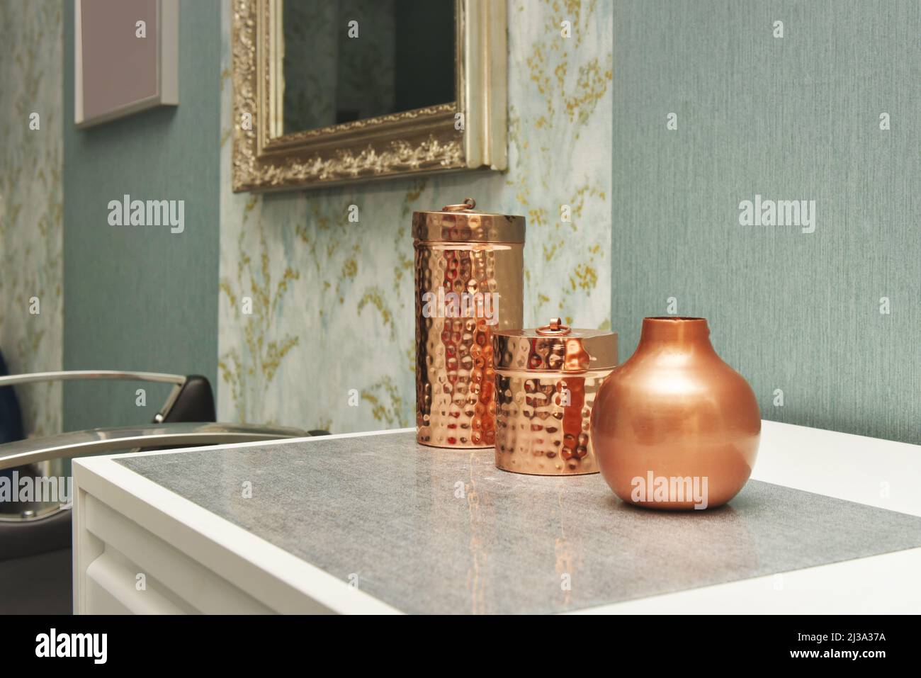 Decorative copper containers on a white chest of drawers and a baroque ...