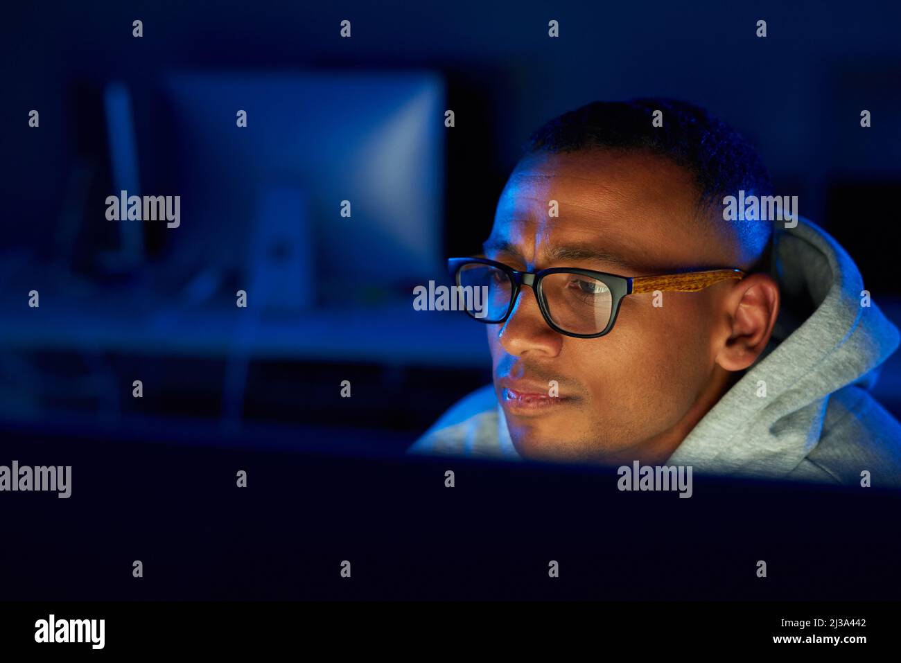 Taking a closer look at things. Shot of a young male hacker cracking a ...