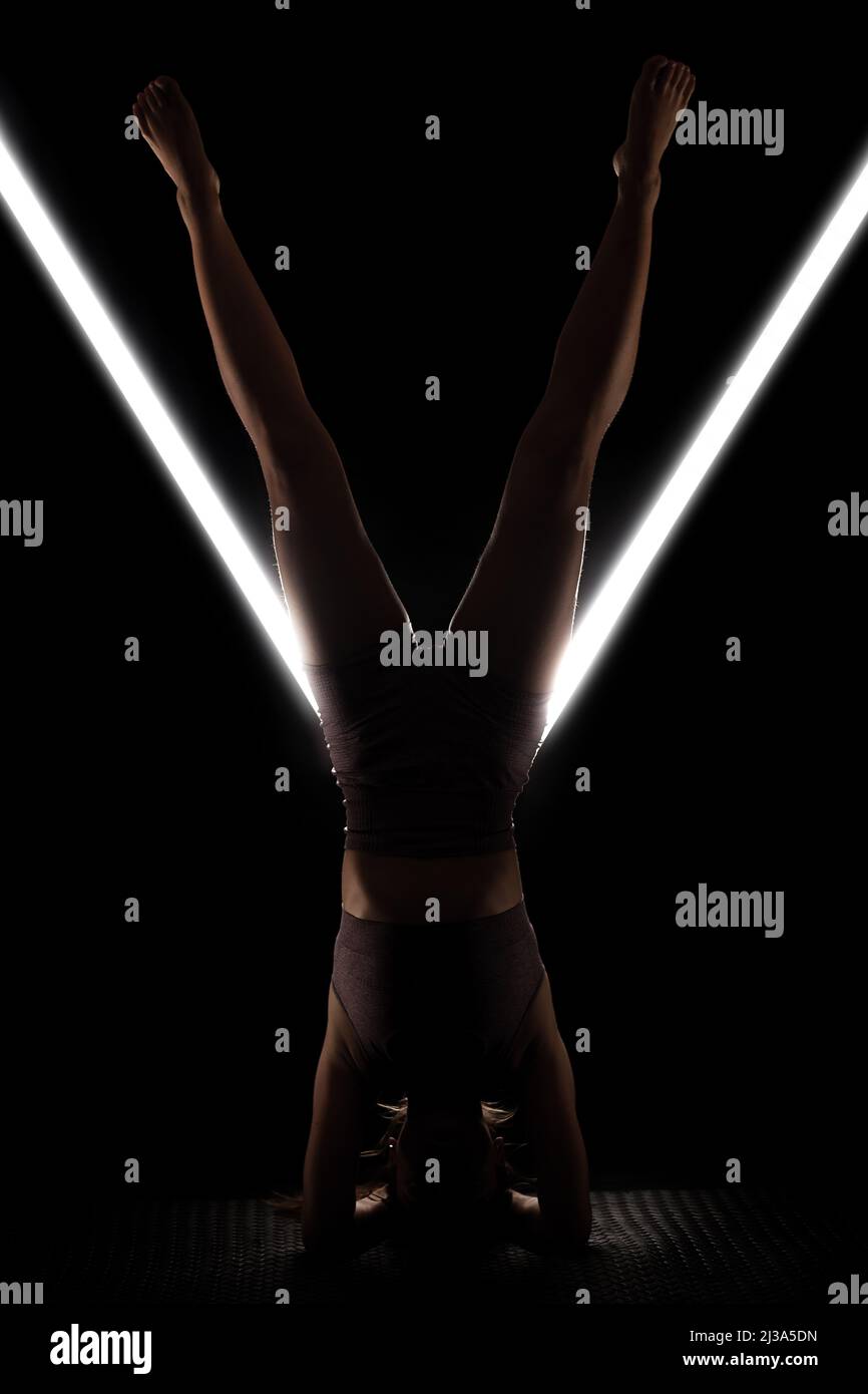 Fit woman practicing yoga poses. Silhouette girl doing exercise in ...