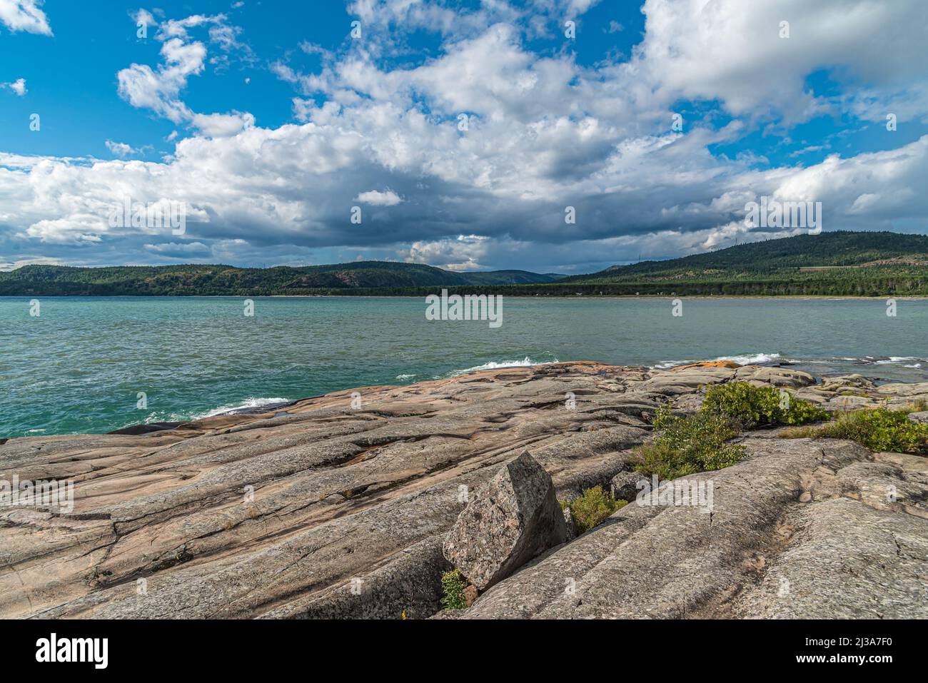 Rocky promontory in Superior Lake under blue cloudy sky. Canada Stock ...