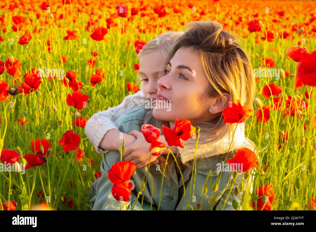 Mother with daughter hugging on the poppies meadow. Beautiful mom and ...