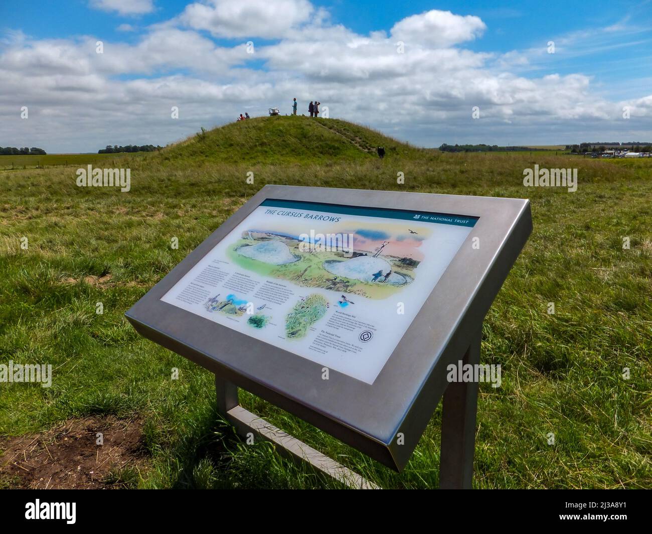 Several people stand atop an ancient barrow, or burial mound, of the ...