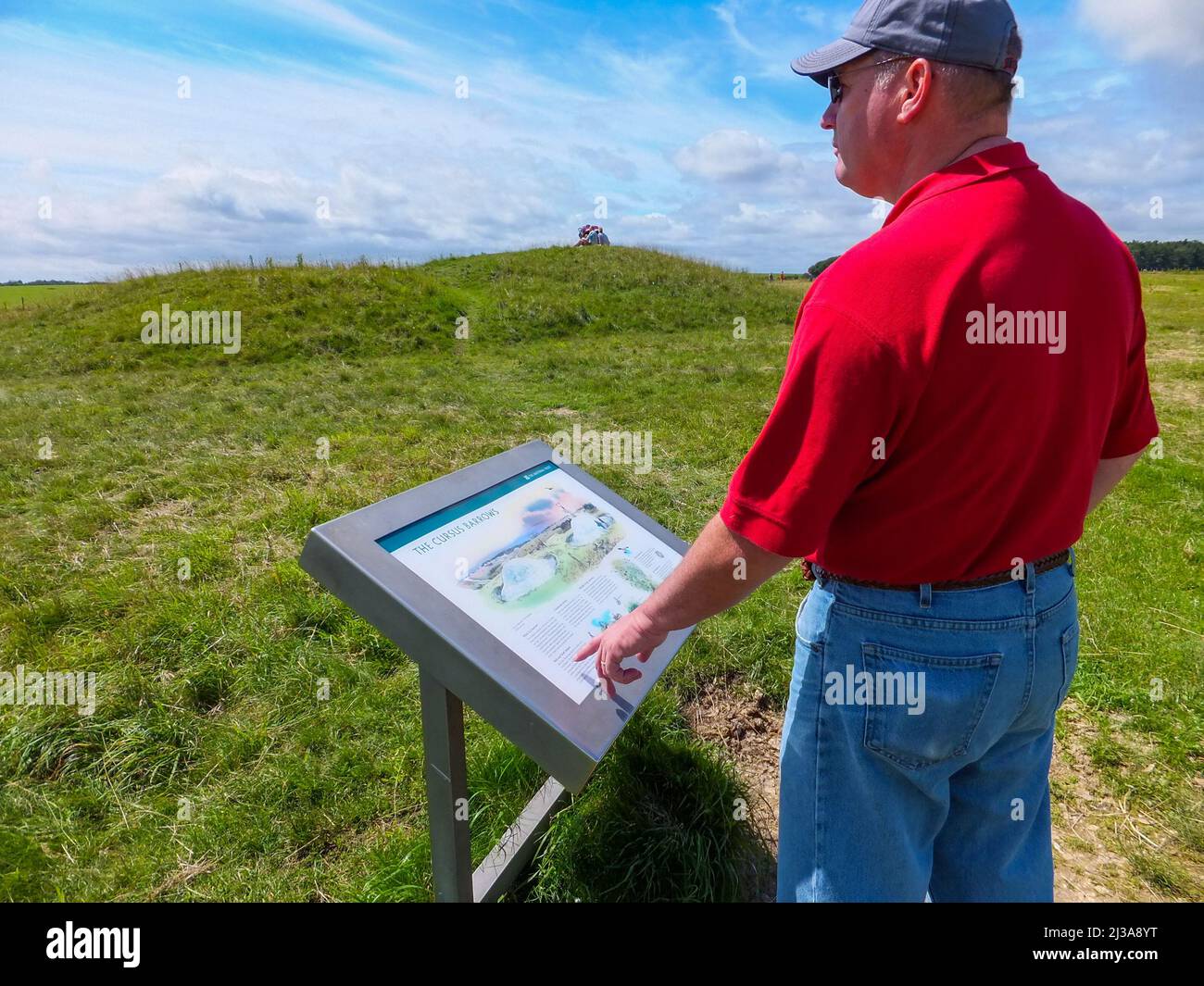 A man looks out over the burial mounds in the ancient Neolithic Cursus ...