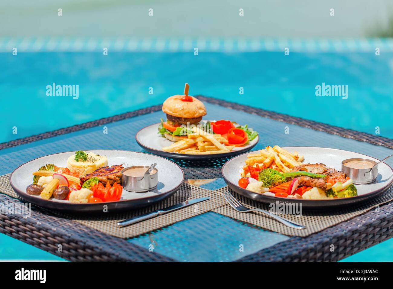 Dinner with cold cocktails near hotel swimming pool. Exotic summer ...