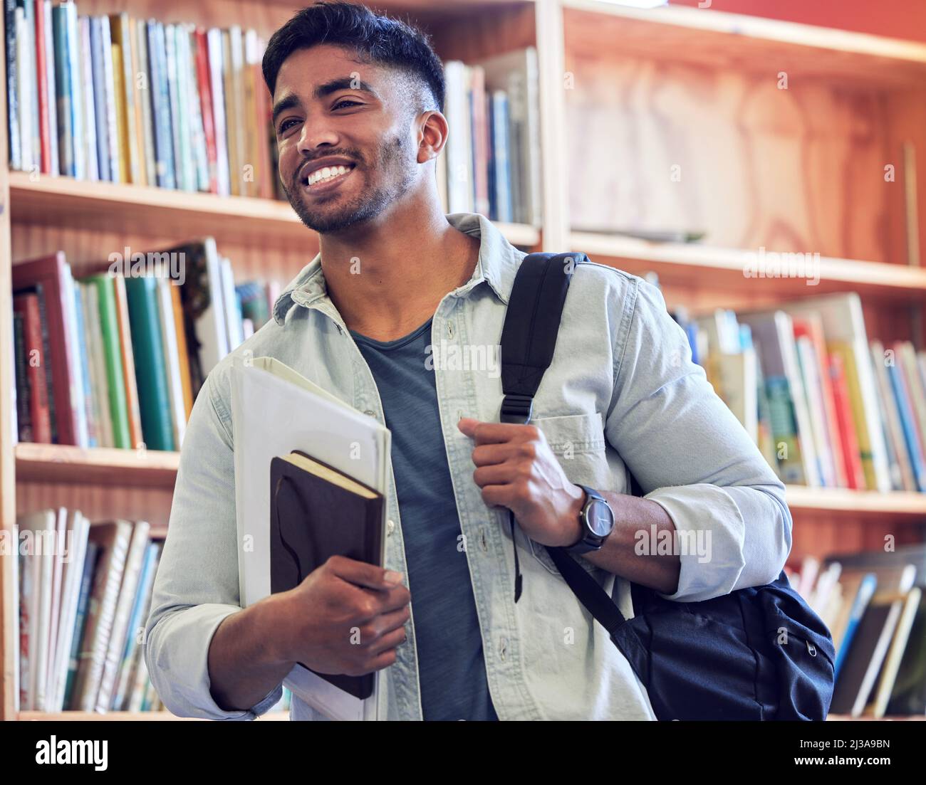 Get studying and go places. Shot of a young man studying in a library ...