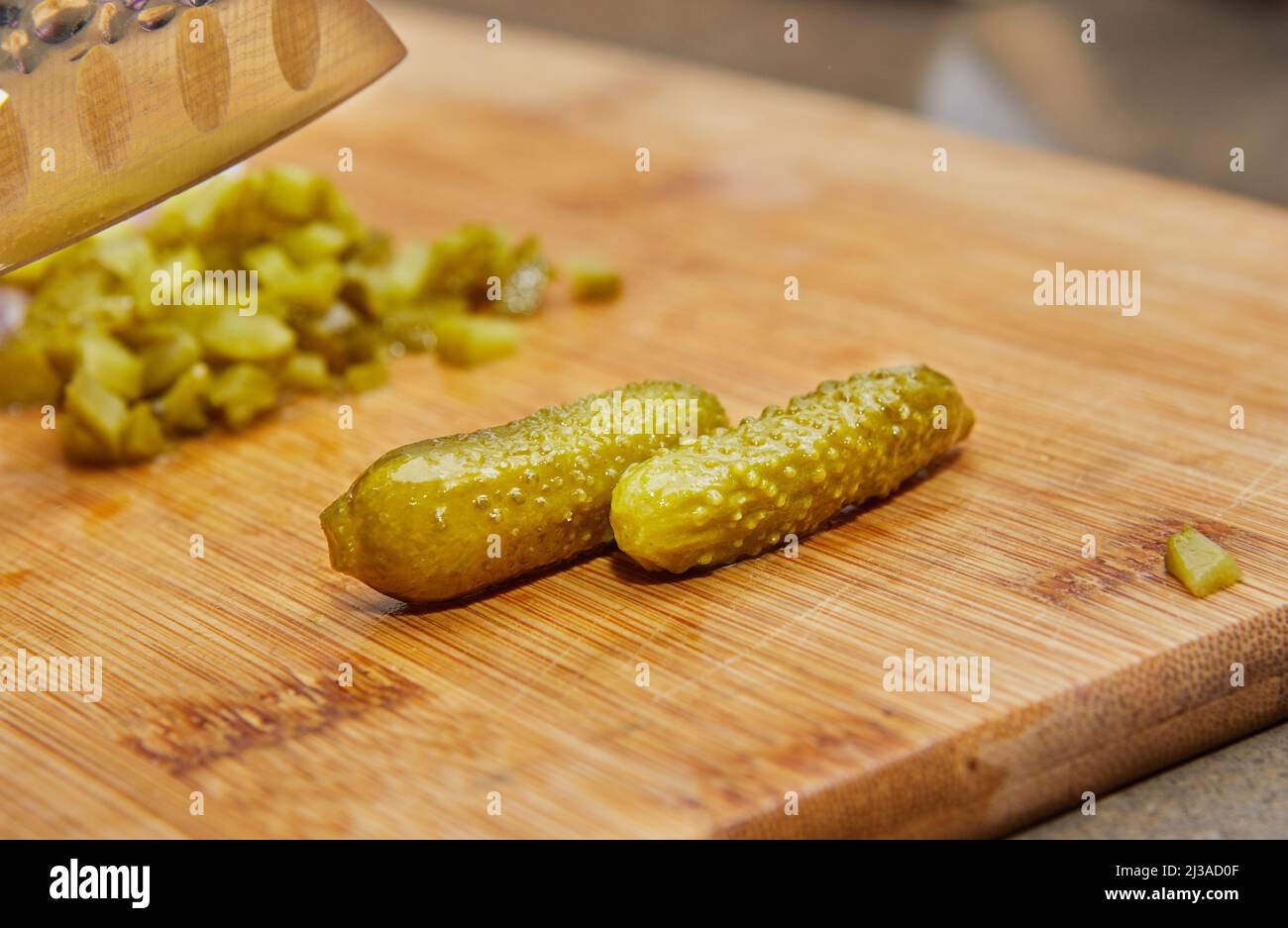 Chef cuts pickles with knife to prepare everything according to the ...