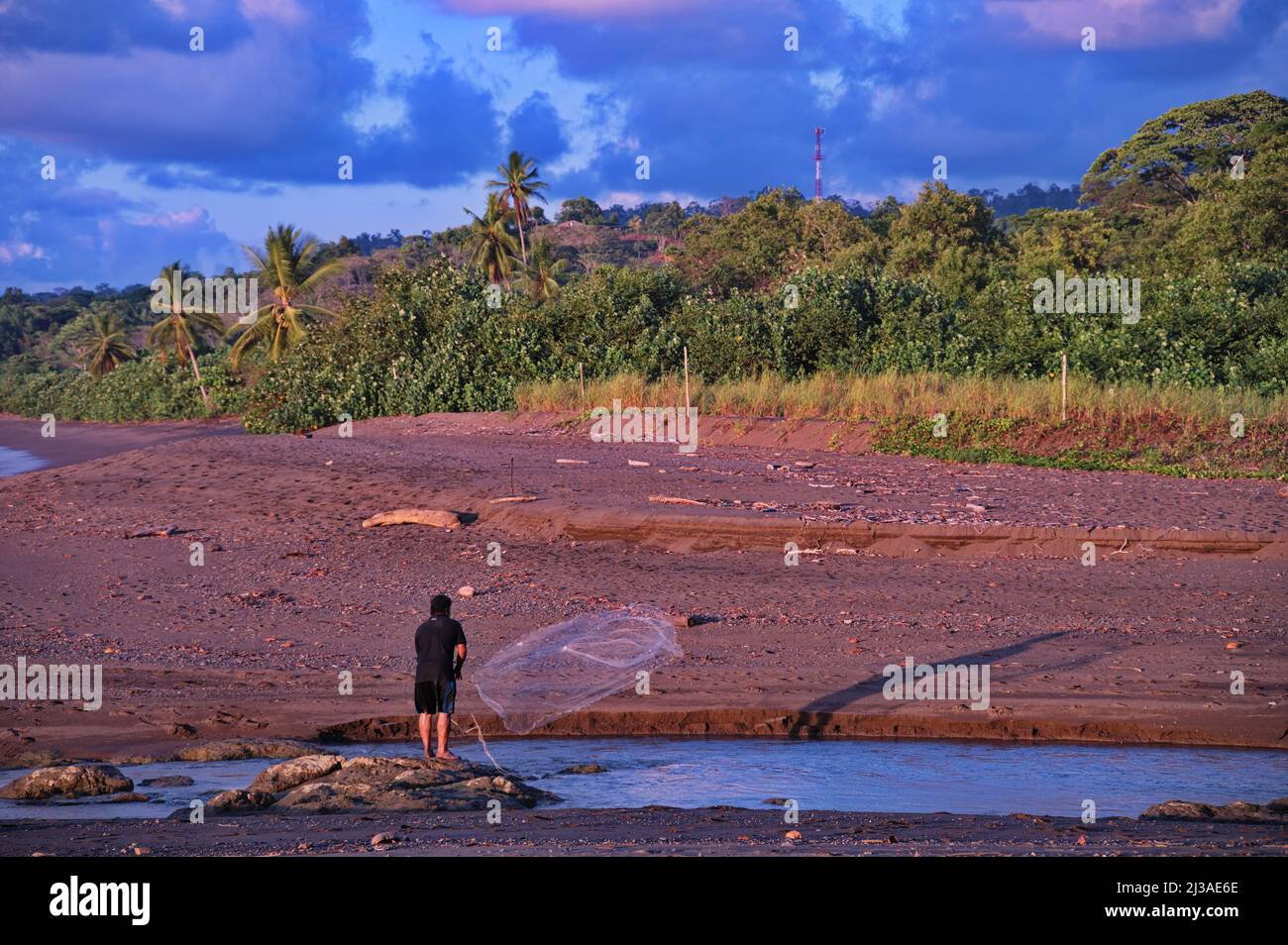Local man fishing with net on the tropical beach Stock Photo - Alamy