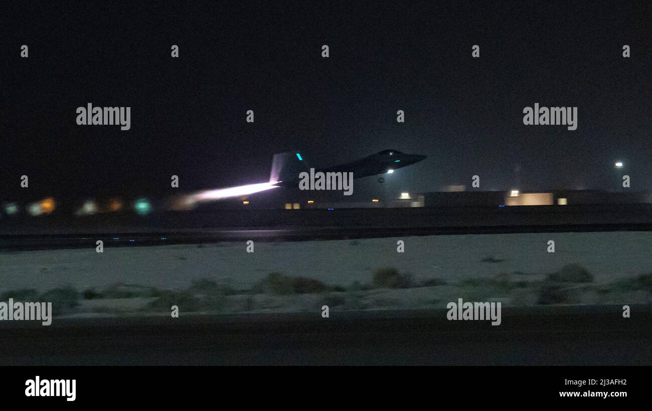 A F-22 Raptor takes off with afterburner during a night mission at Al ...