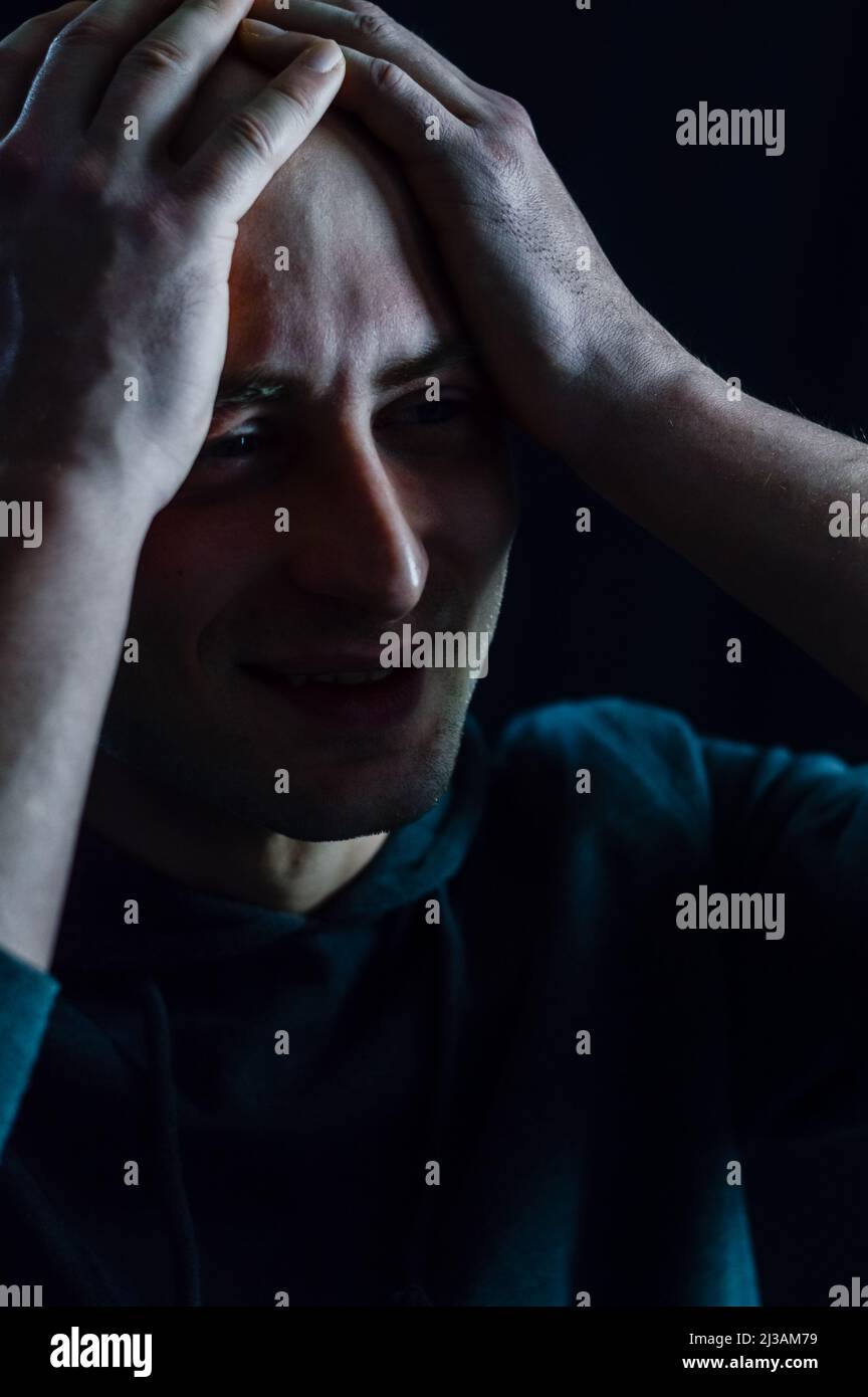 Portrait of a young bald man who with his hands on his head looks ...