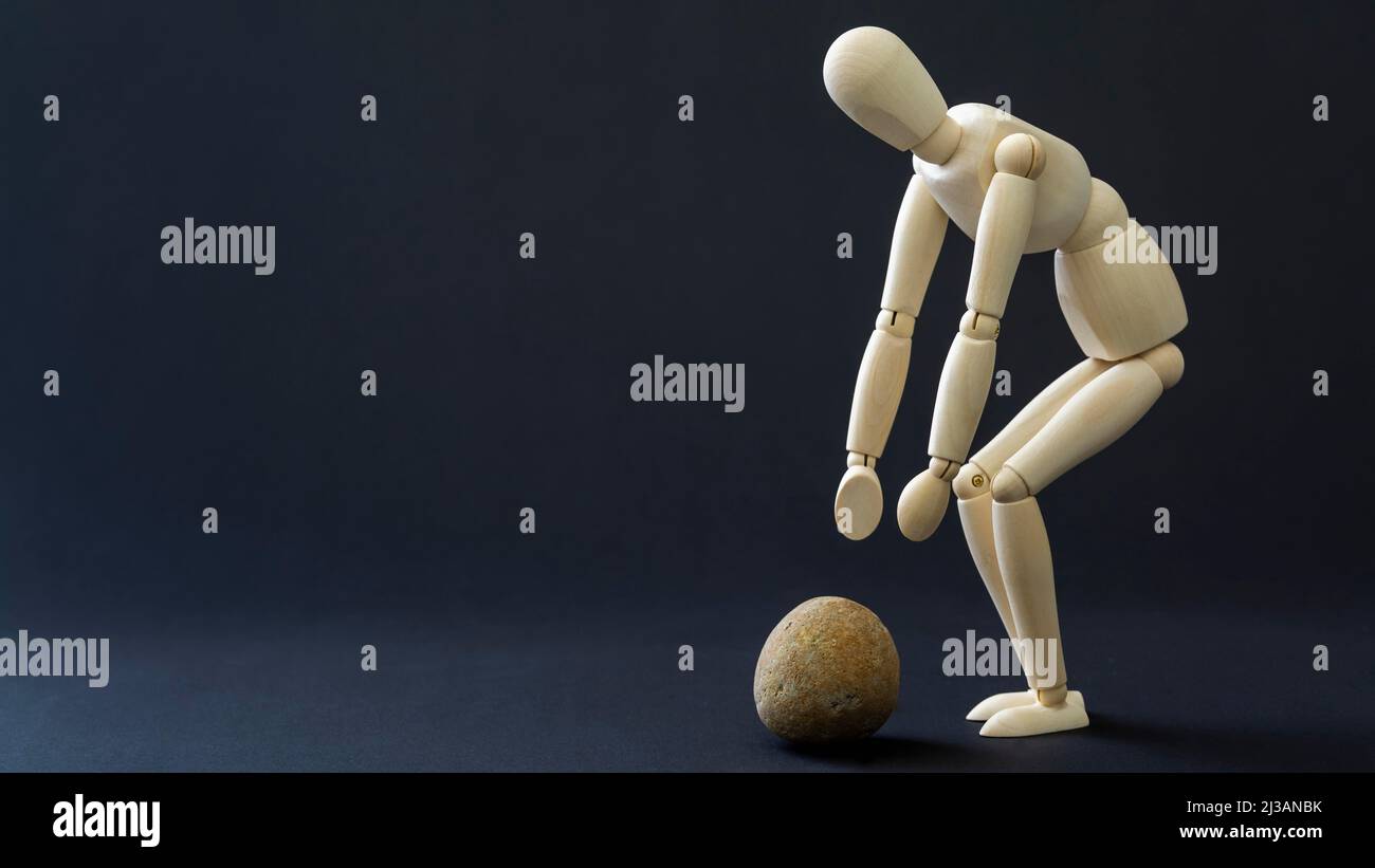The mannequin is picking up the stone, symbolic image Stock Photo - Alamy