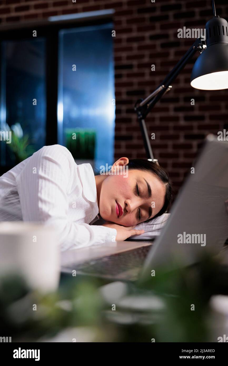 Portrait shot of tired businesswoman sleeping on desk in office ...