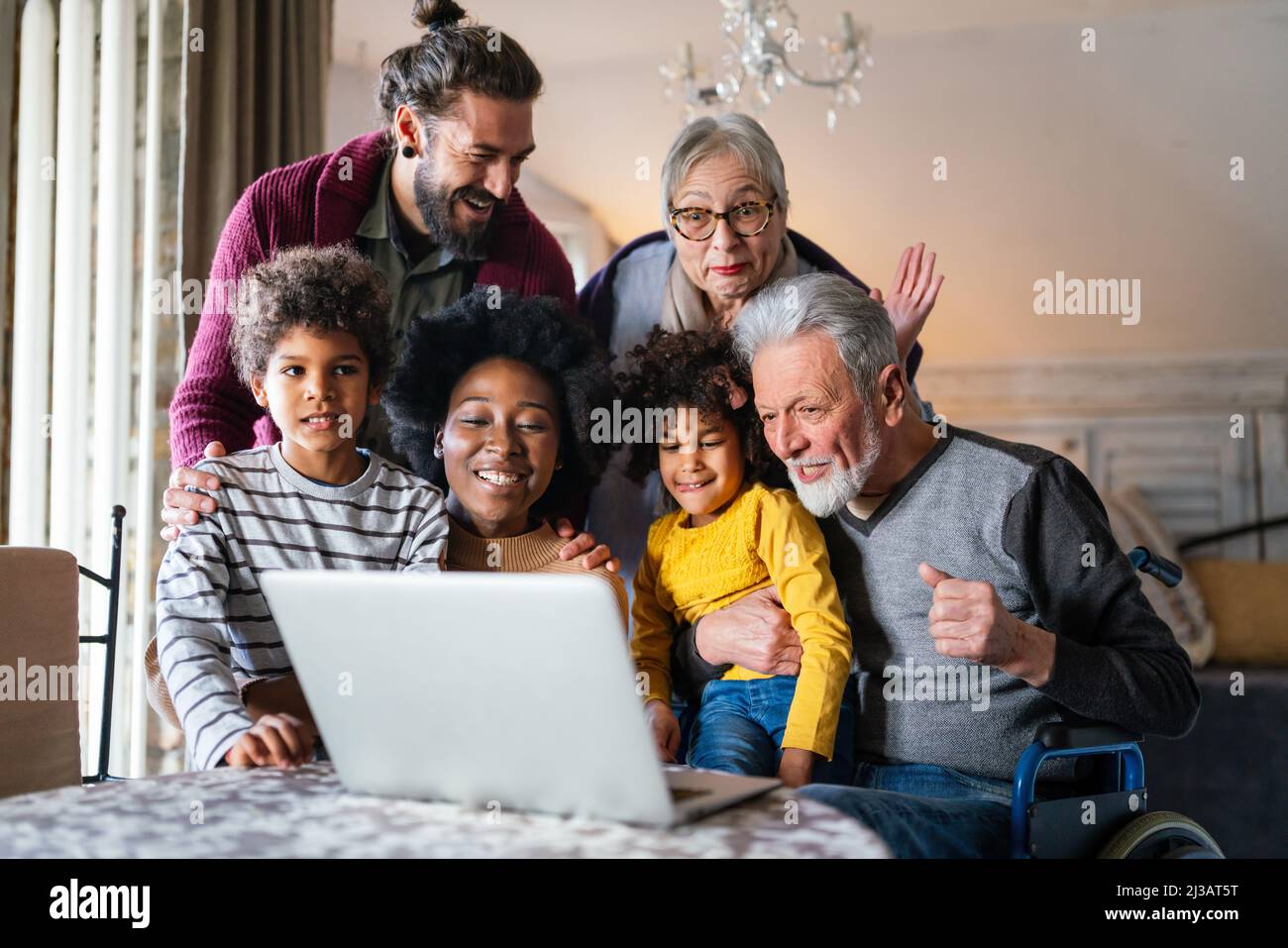 Extended multiethnic family together at home during video call. People ...