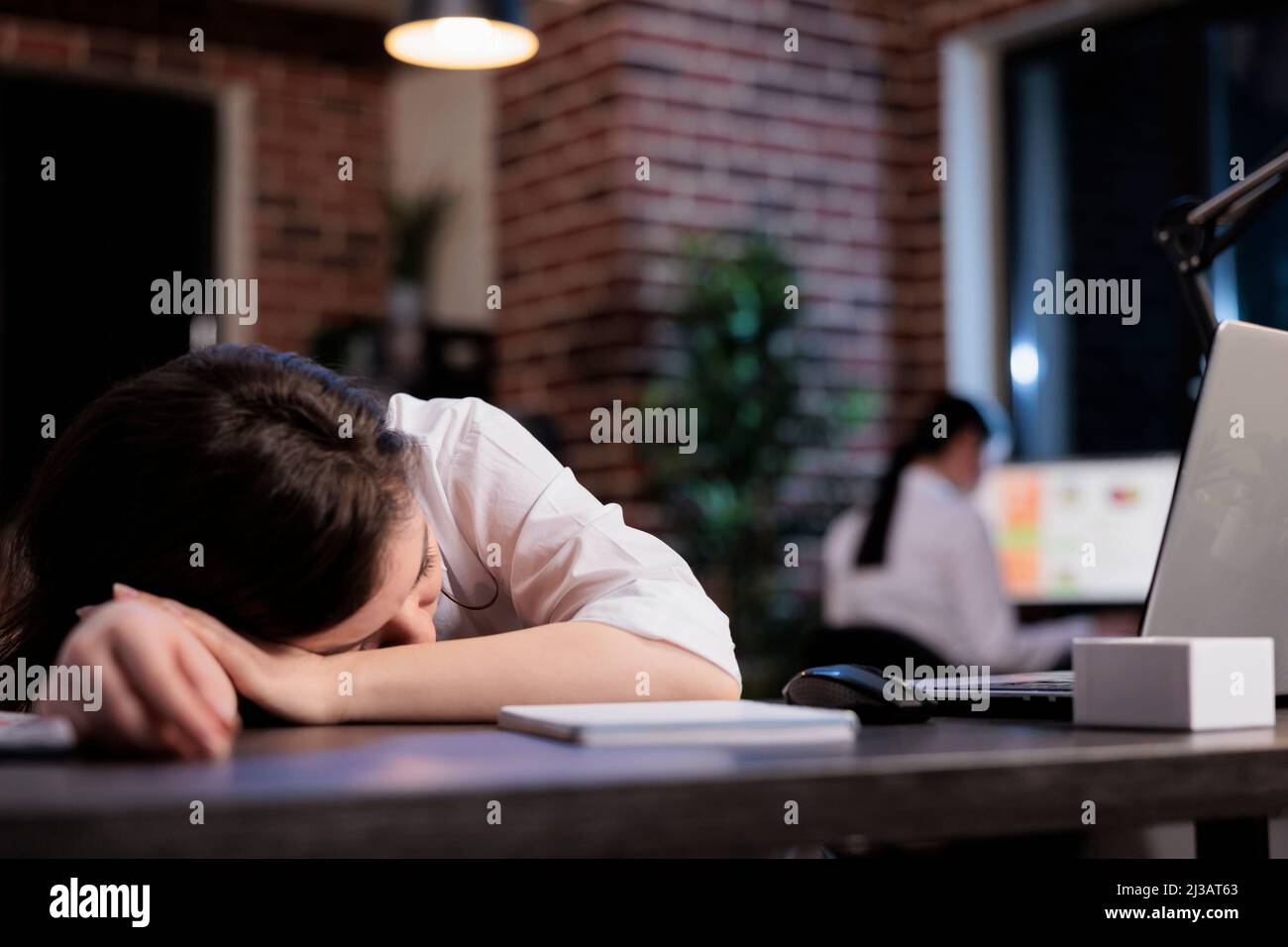 Fatigued marketing agency employee sleeping on desk because of overtime ...