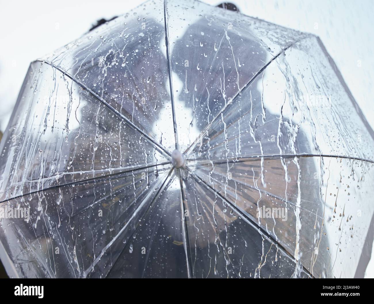 The perfect weather for cuddling. Shot of a couple shielding themselves ...