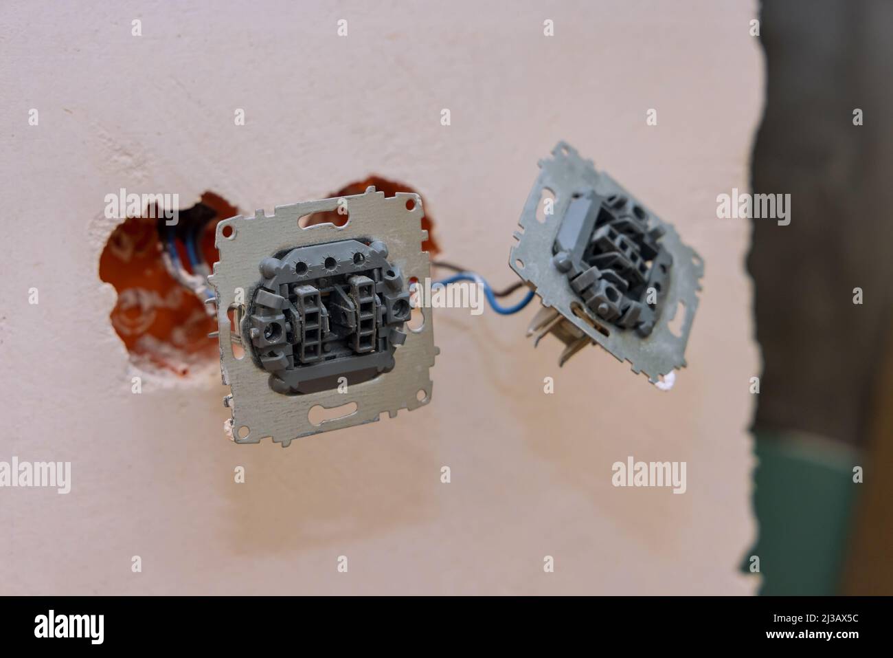 Installing light switch on under painted wall on newly home Stock Photo ...